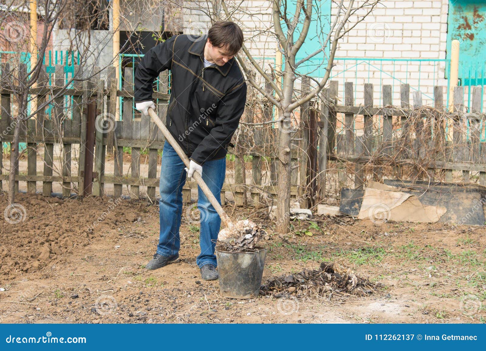 A Man on a Country Site Collects the Garbage in a Bucket Stock Image ...