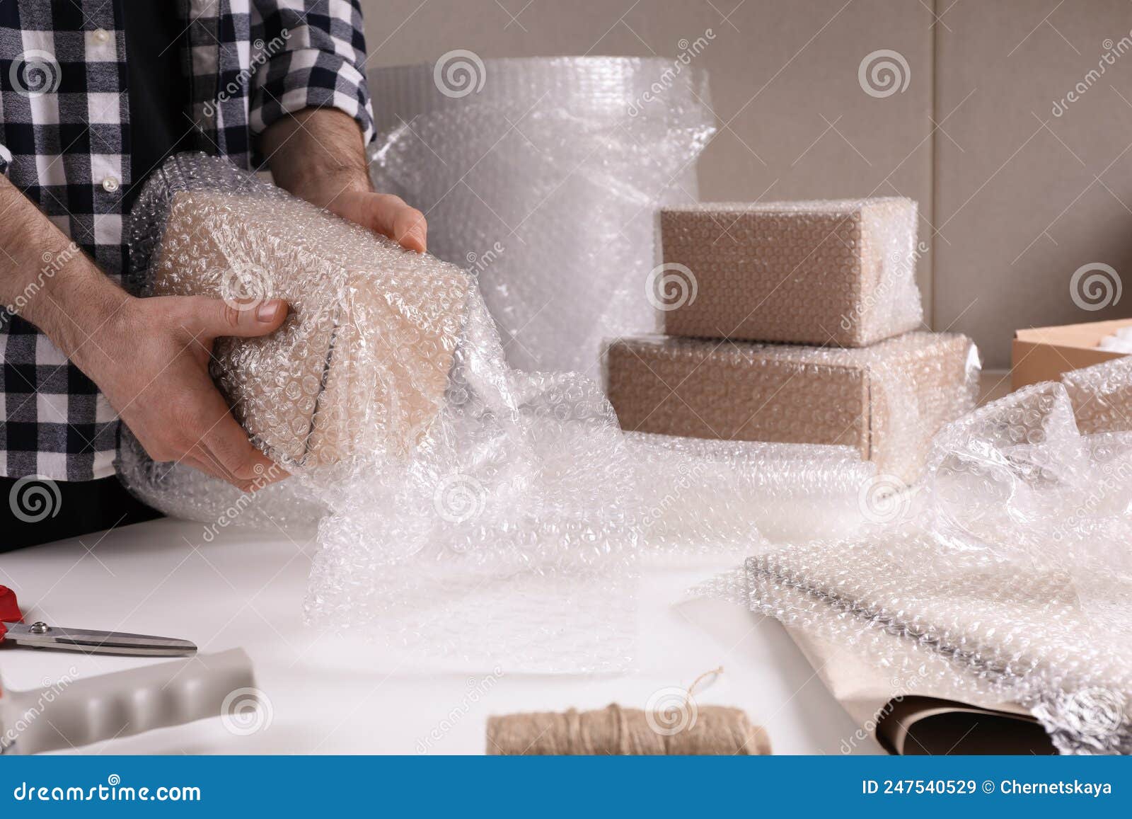 Man Covering Box with Bubble Wrap at Table in Warehouse, Closeup Stock ...
