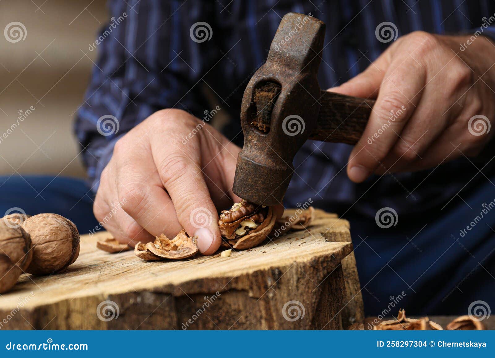 Man Cracking Walnuts with Hammer at Table, Closeup Stock Photo - Image ...