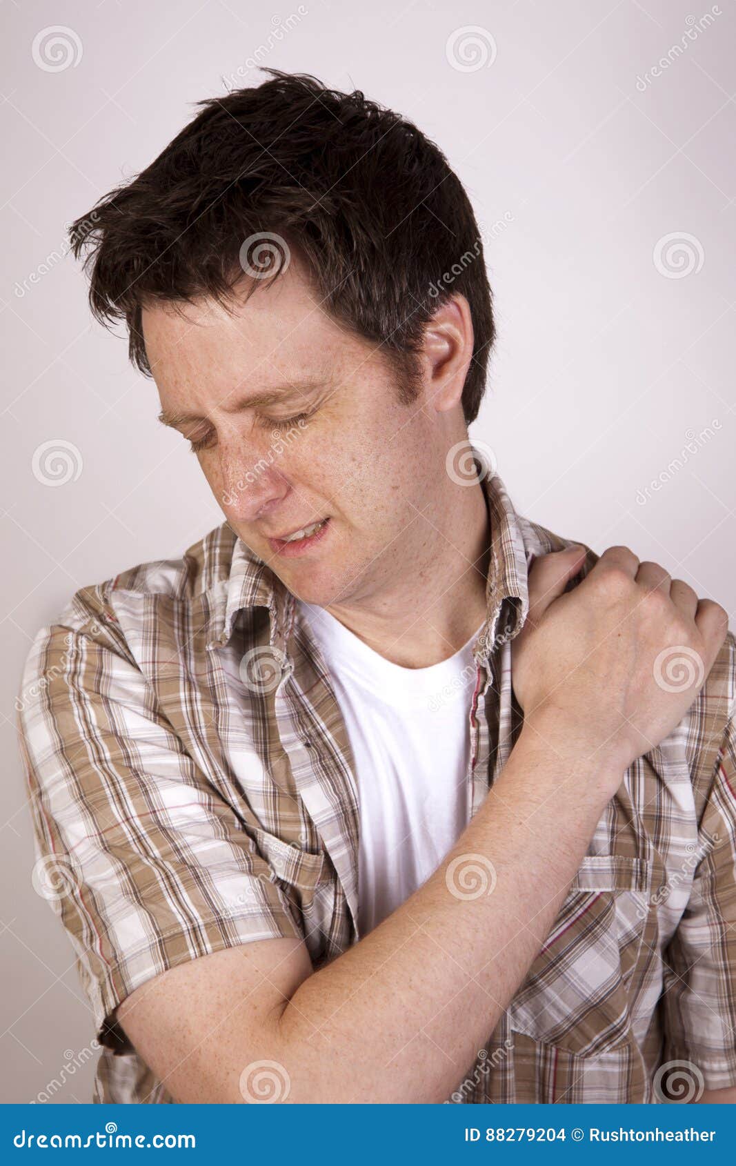 Man Cringing from Pain Holding His Shoulder Stock Photo - Image of ...