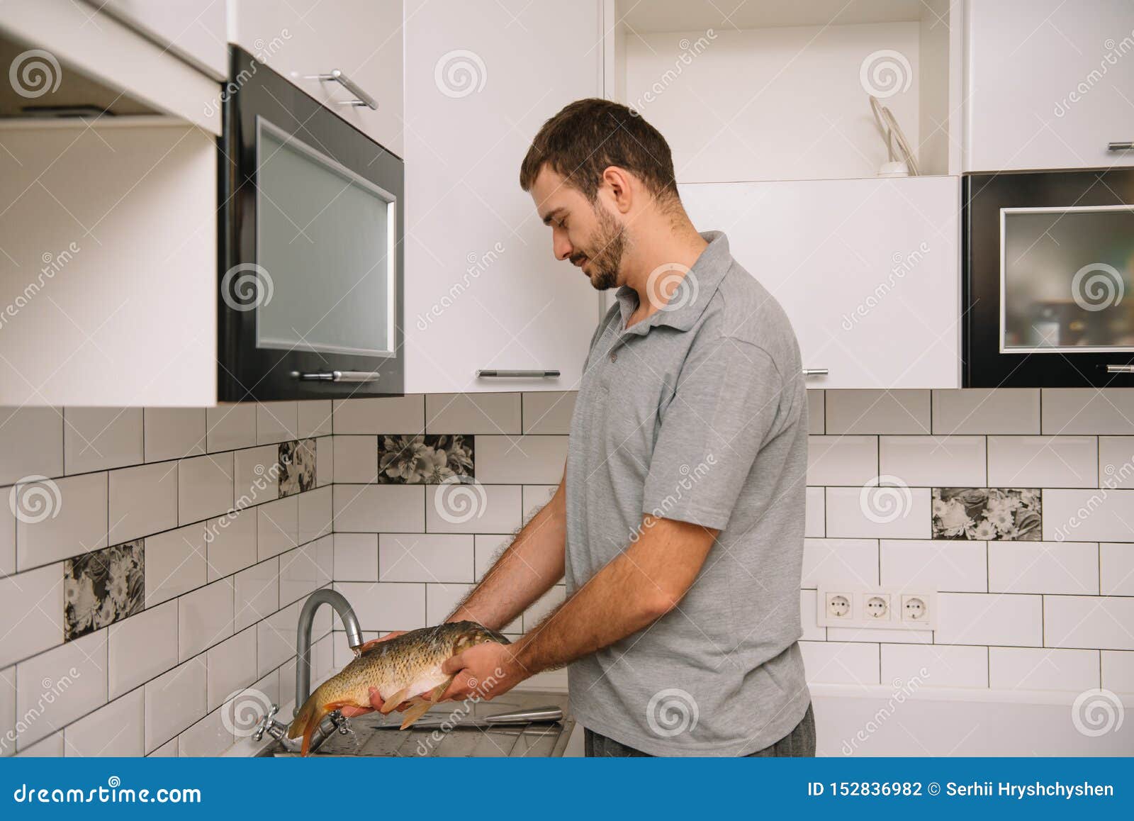 Man Cutting Fresh Fish in Kitchen in Home. Man Butchering Fish for Cook ...