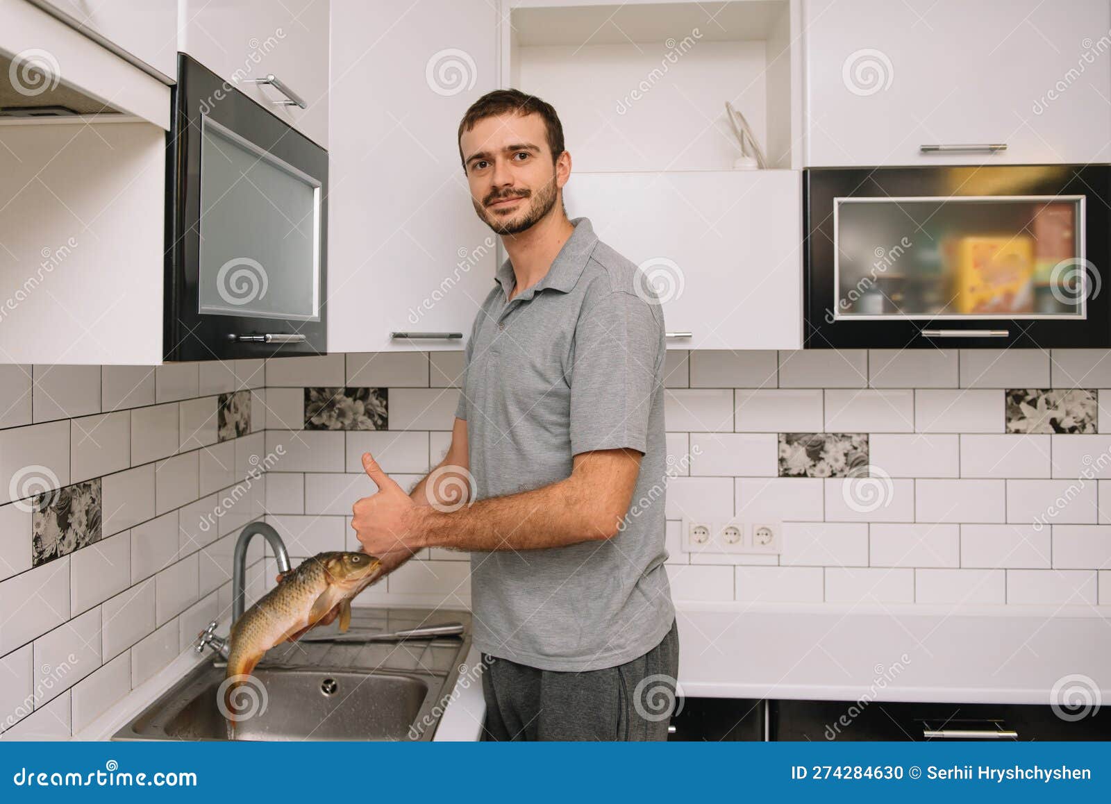 Man Cutting Fresh Fish in Kitchen in Home. Man Butchering Fish for Cook ...
