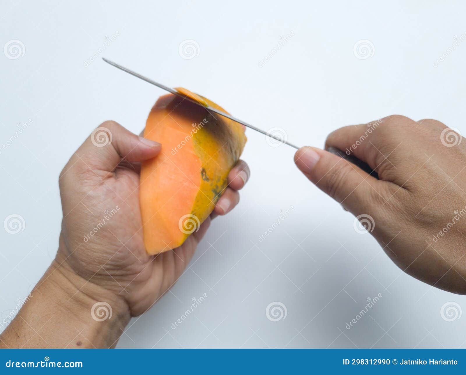 Man Cutting a Papaya Fruit with a Knife on a White Background, Isolate ...