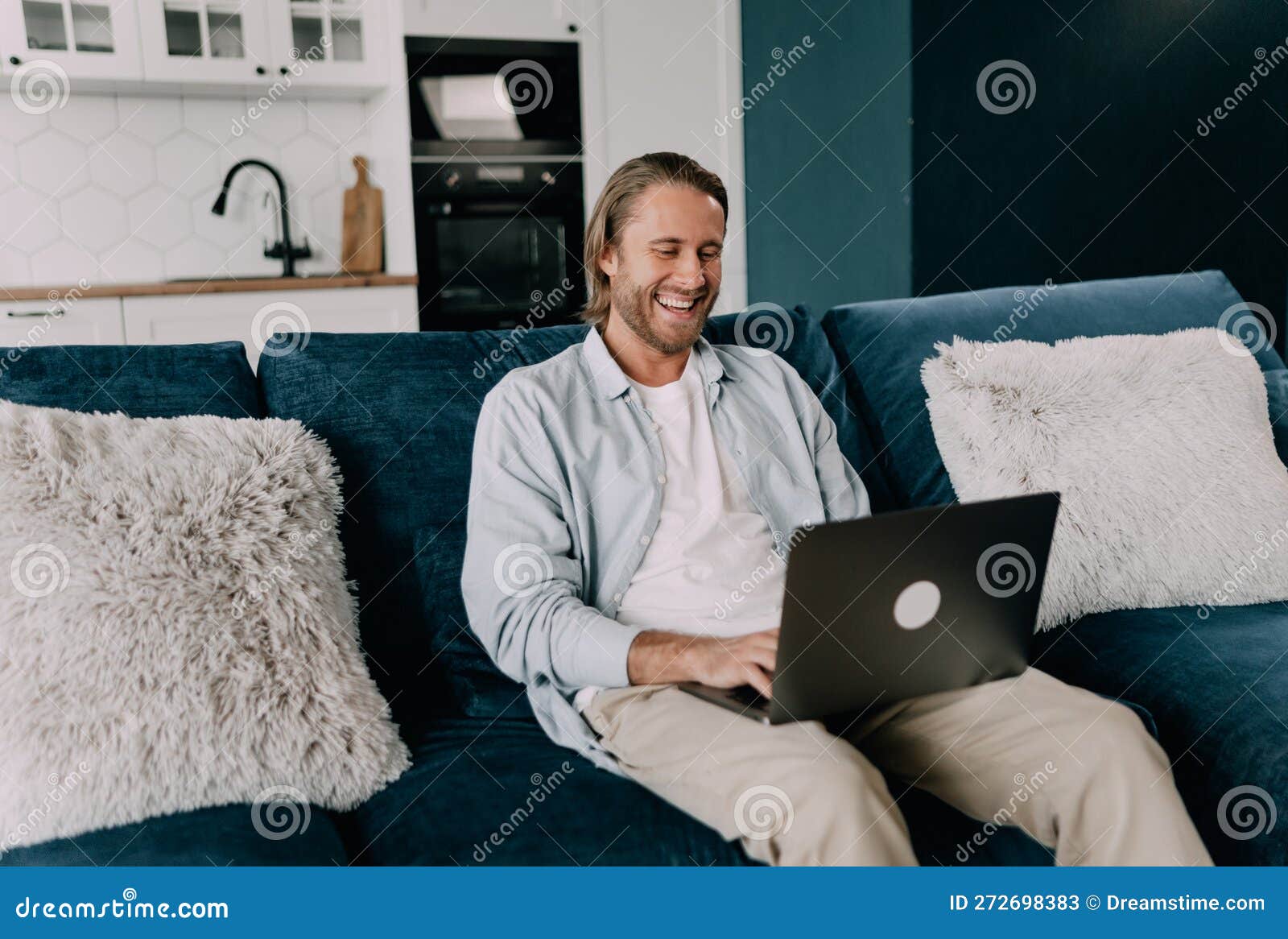 A Man with a Delighted Smile Surfing the Net. Casually Dressed Relaxed ...