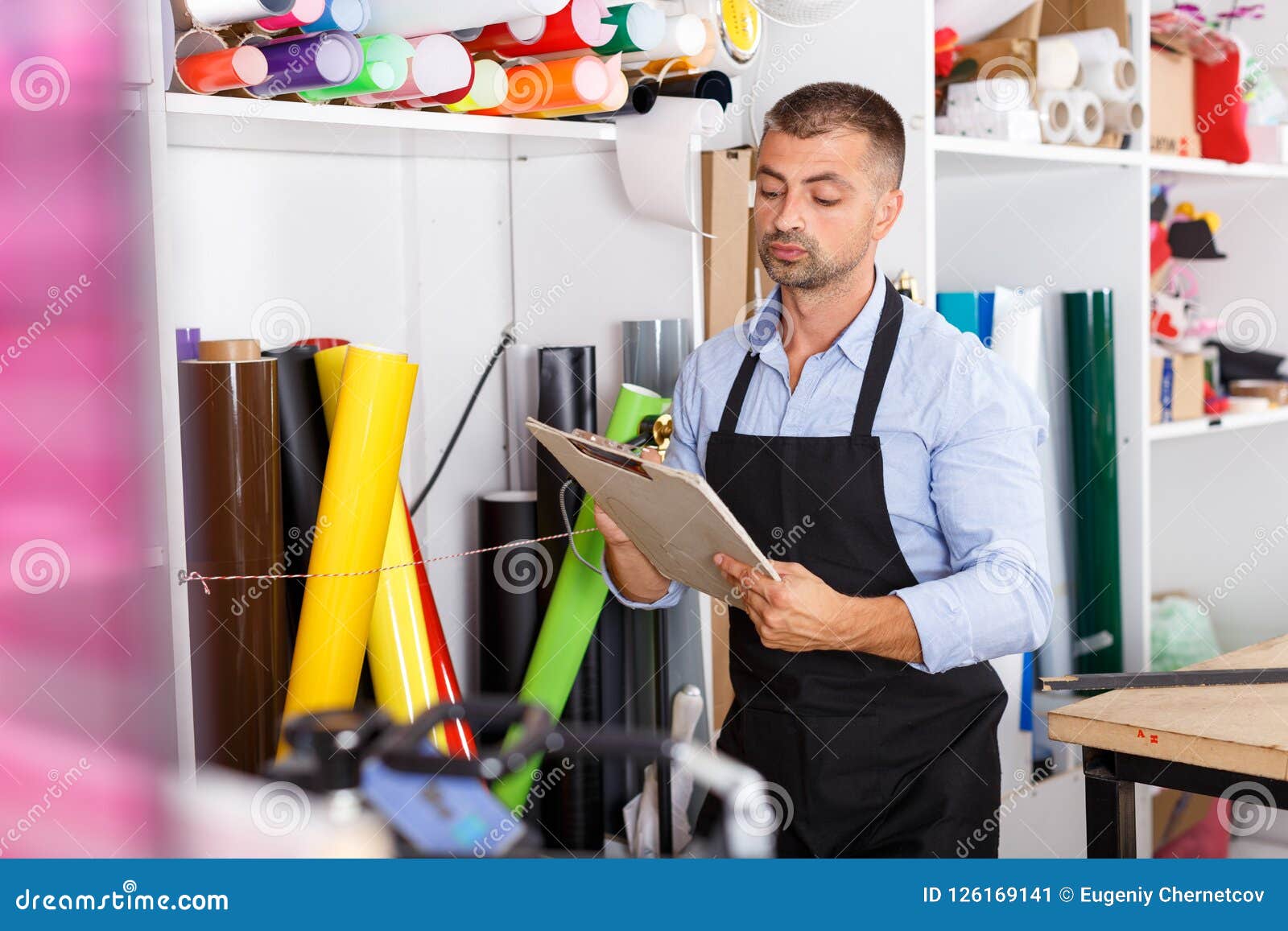 Man Designer and Print Operator with Vinyl Paper at Print Manufacturing ...