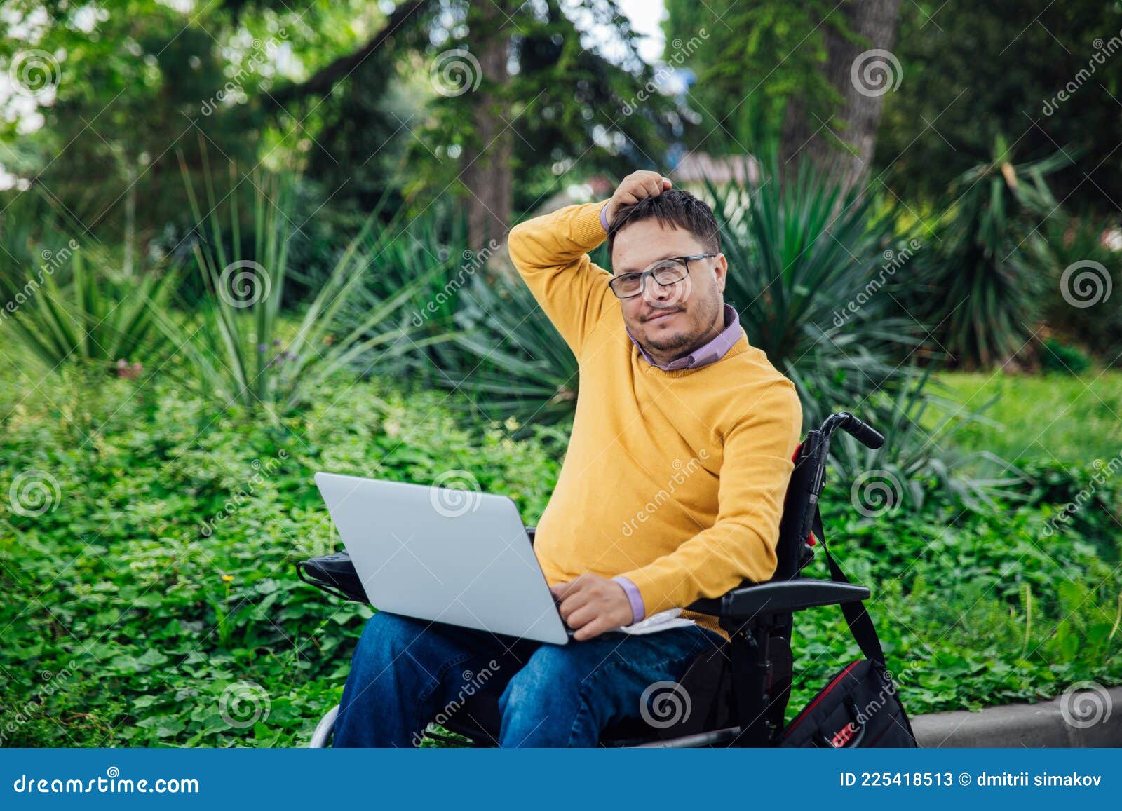 A Man with Disabilities in a Wheelchair Works at a Computer on the ...