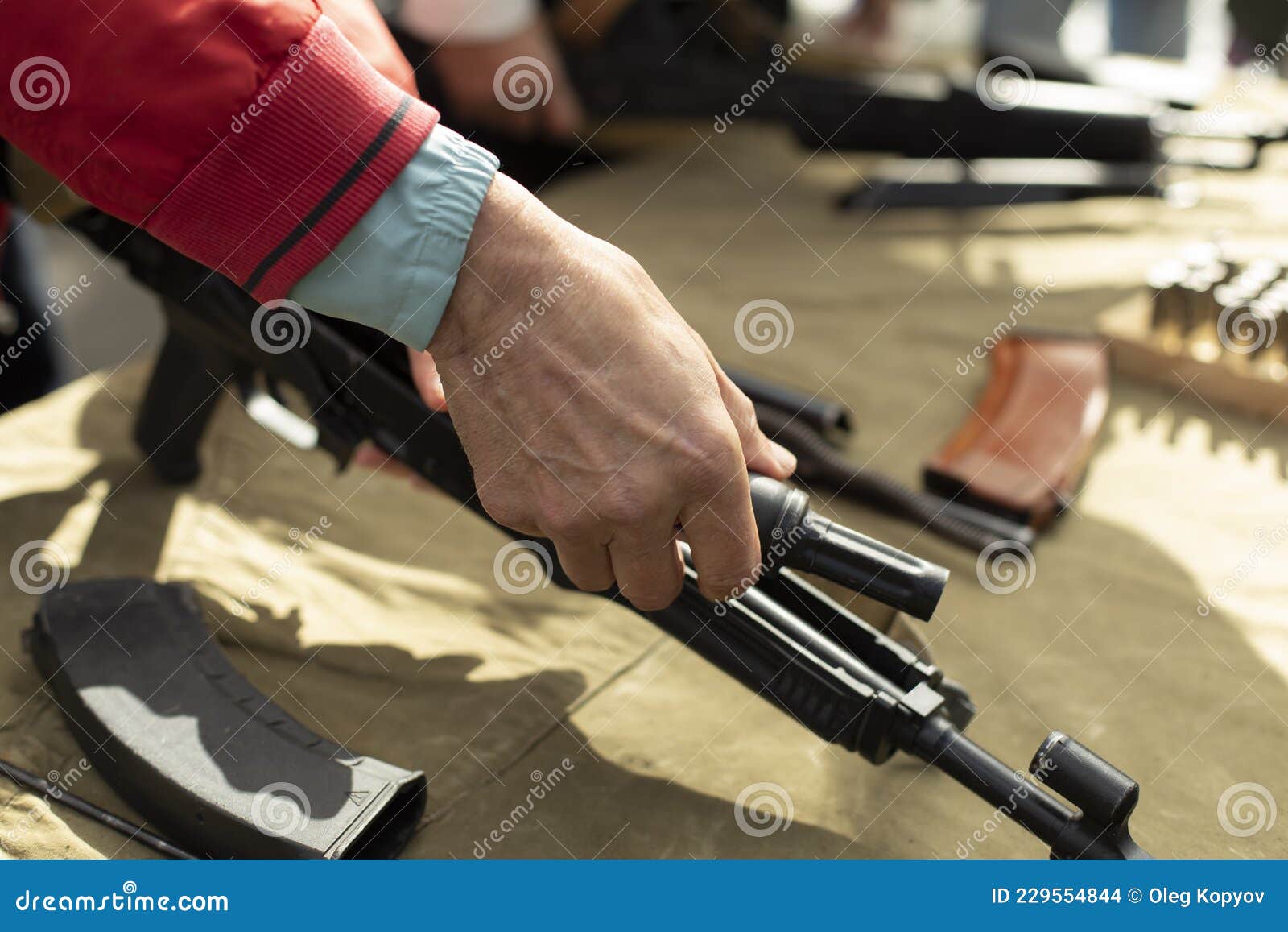 A Man Disassembles a Firearm. a Person Undergoes Military Training ...