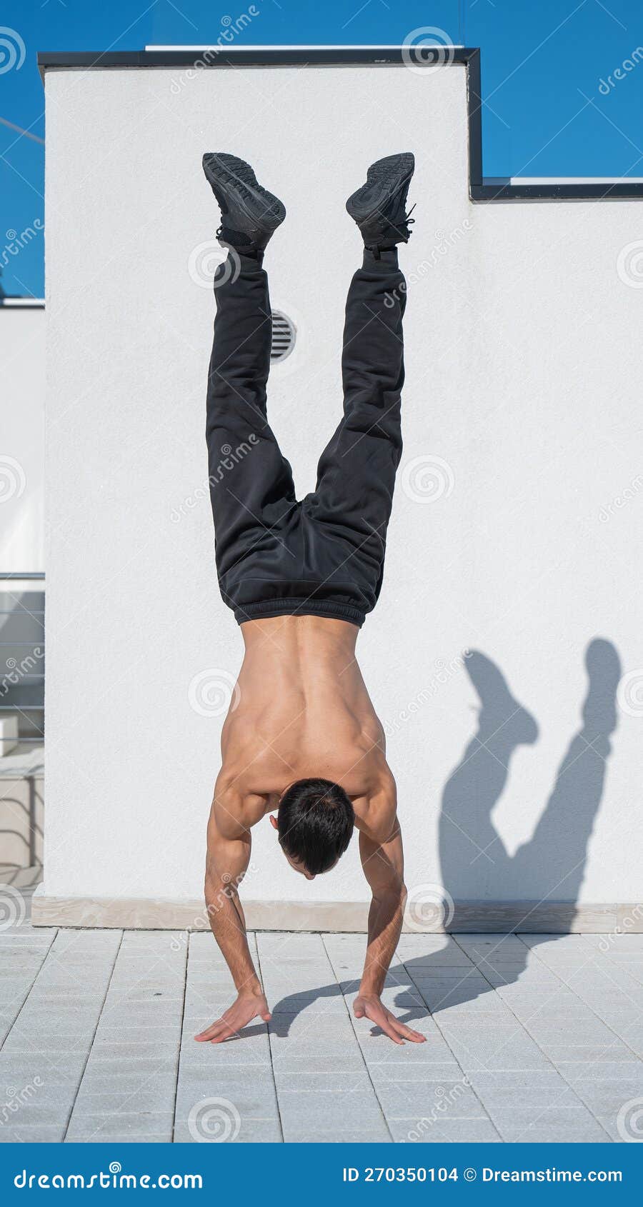 Man Doing a Handstand Outdoors Against a White Wall. Stock Photo ...