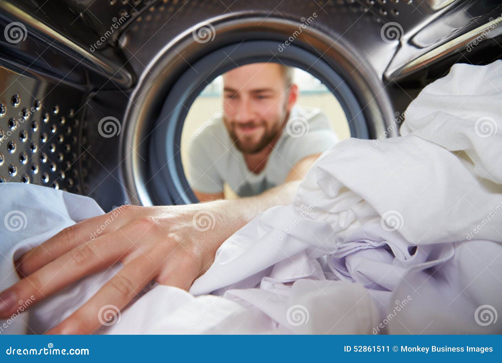 Man Doing Laundry Reaching Inside Washing Machine Stock Image - Image ...