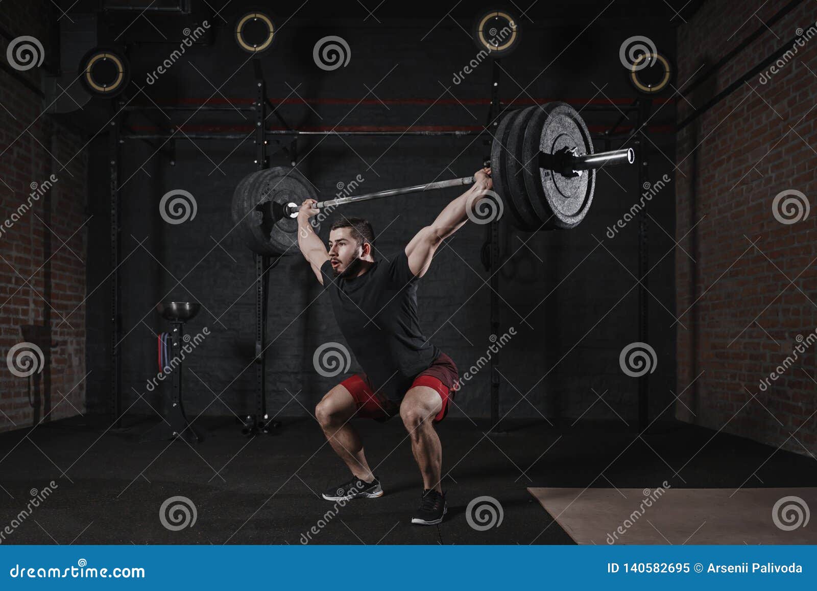 Man Doing Squats with Heavy Barbell Overhead at Gym. Handsome Man ...