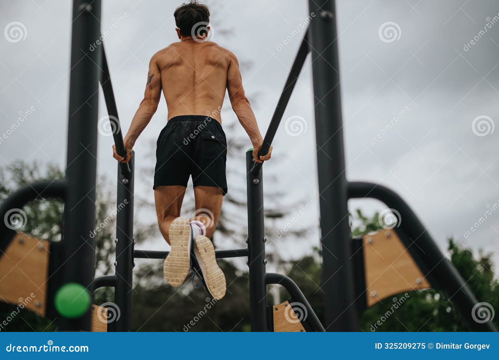 Man Doing Workout on Parallel Bars Outdoors on a Cloudy Day Stock Image ...