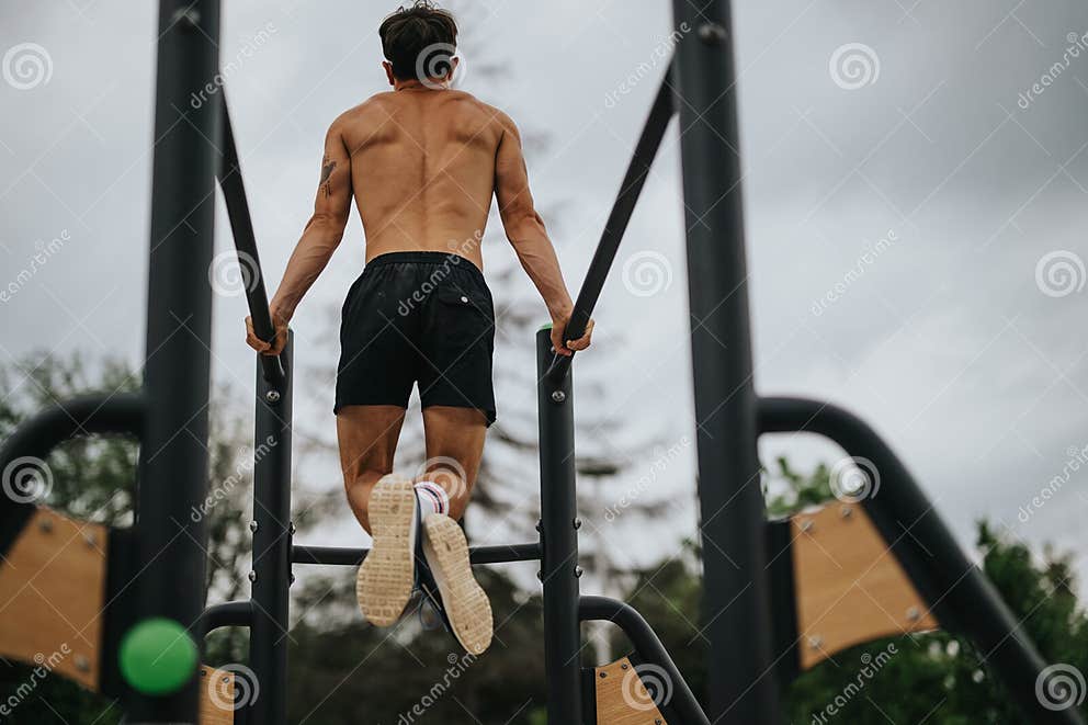 Man Doing Workout on Parallel Bars Outdoors on a Cloudy Day Stock Image ...