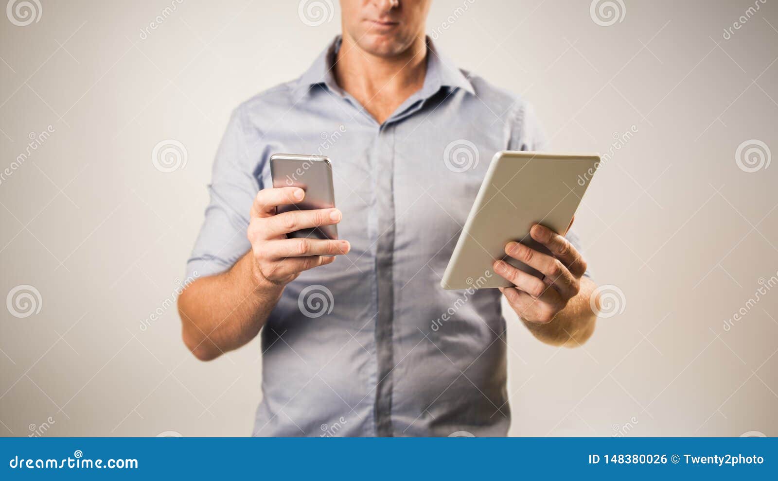 Man Dressed Casually in Collared Shirt Using a Tablet and Phone Stock ...
