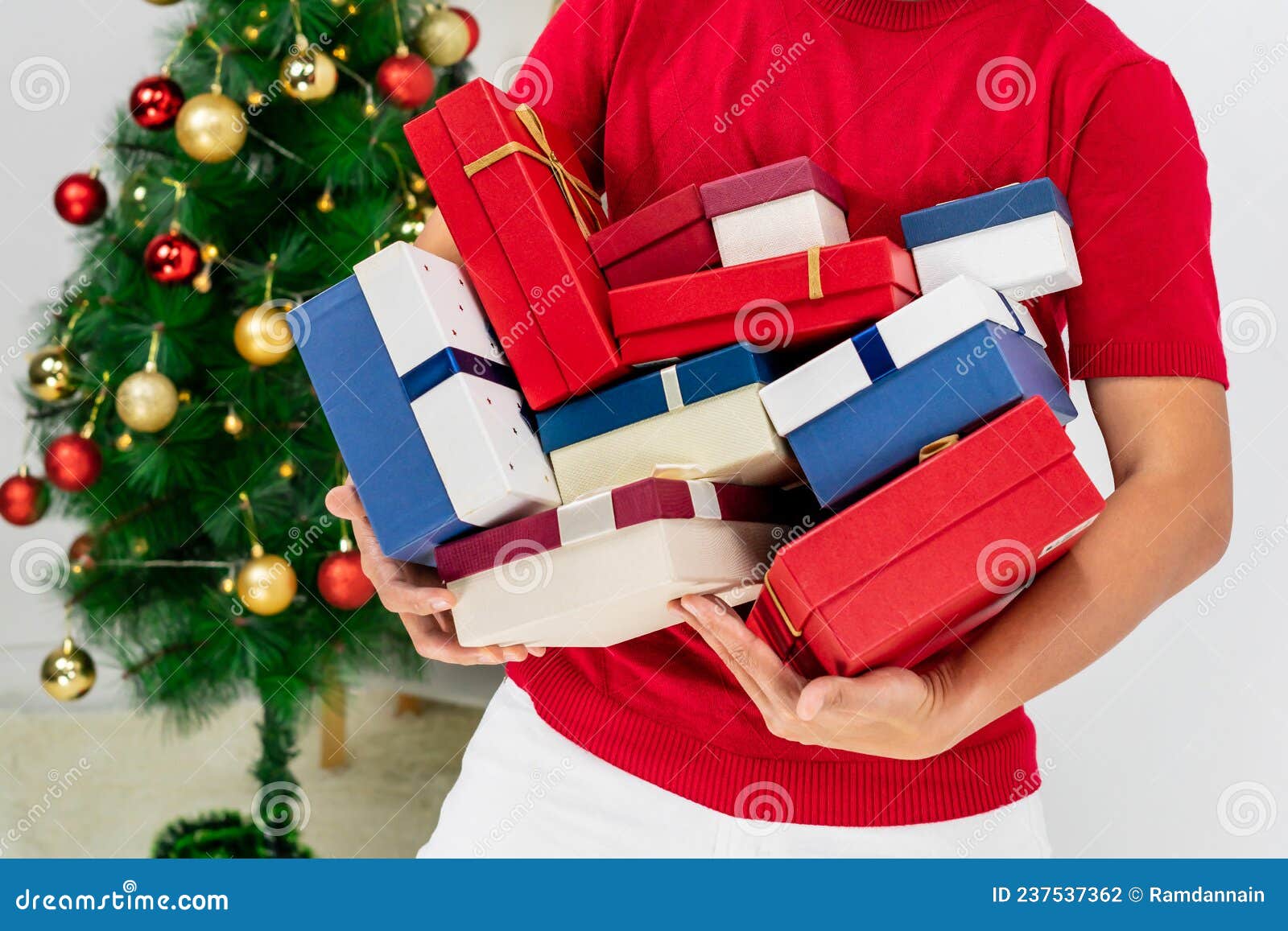 A Man Dressed in Red Carrying a Stack of Gift Boxes with a Christmas ...