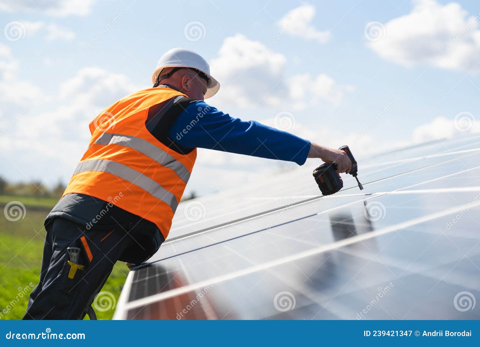 Man with Drill Screwdriver Installs Panels at a Solar Power Plant ...