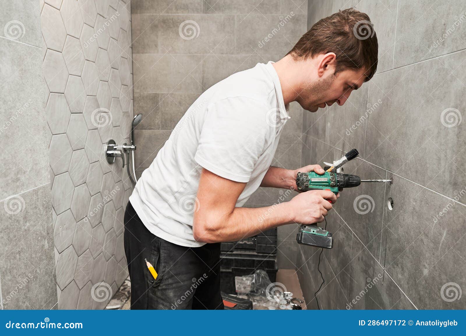Man Drilling Wall with Electric Power Drill in Bathroom. Stock Photo ...