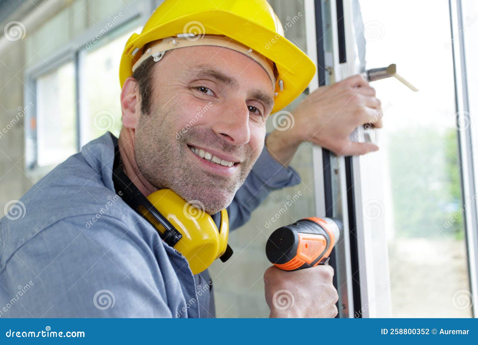 Man drilling window frame stock photo. Image of helmet - 258800352