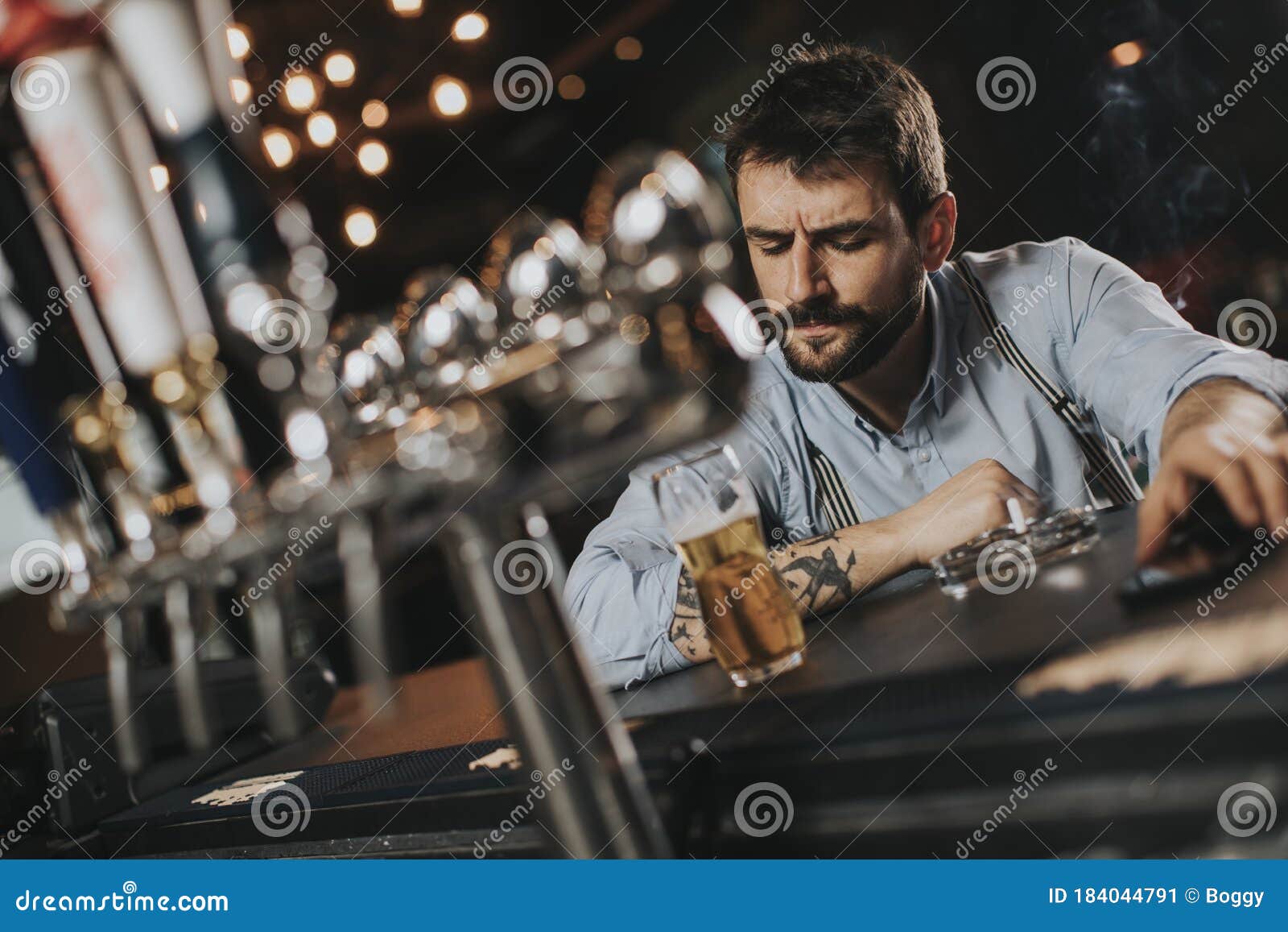 Man Drinking Beer and Smoking Cigarette at Pub in the Night Club Stock ...