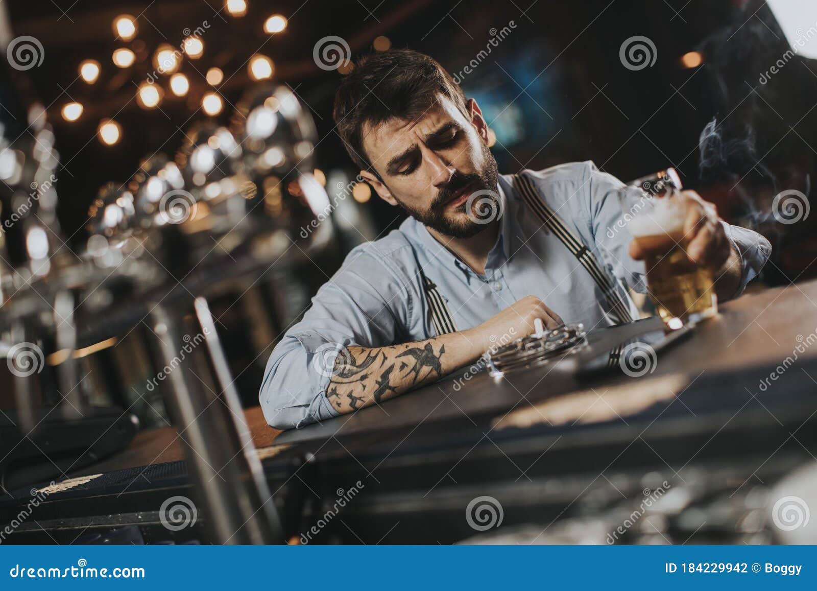 Man Drinking Beer and Smoking Cigarette at Pub in the Night Club Stock ...