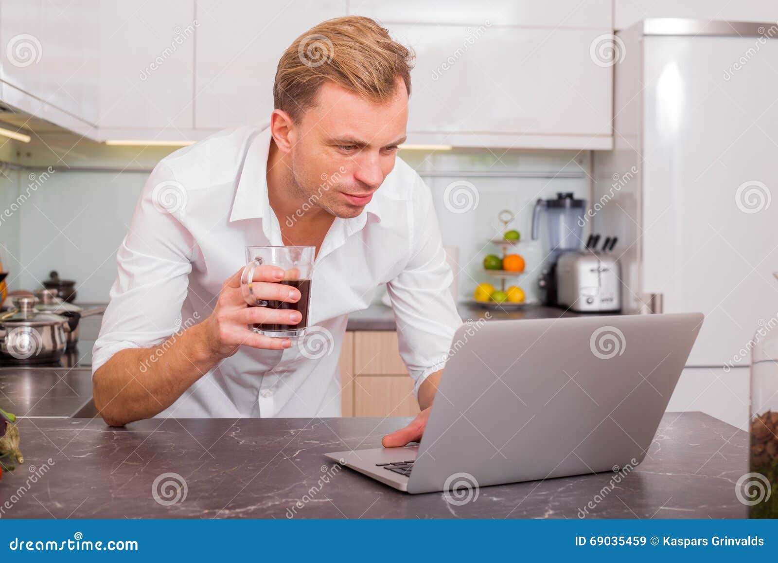Man Drinking Coffee and Using Computer in Kitchen Stock Image - Image ...