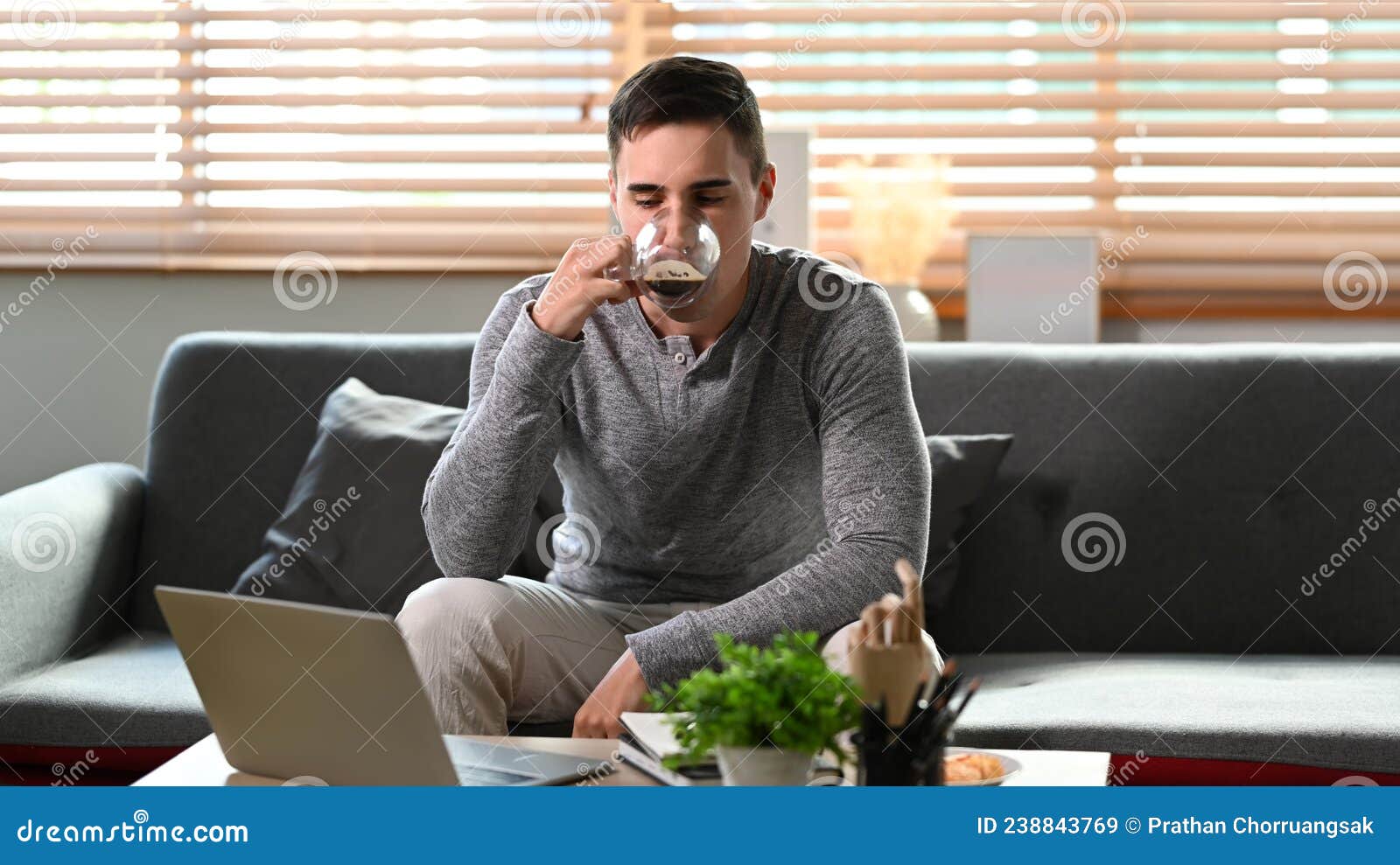 Man Drinking Coffee and Using Computer Laptop on Couch. Stock Image ...