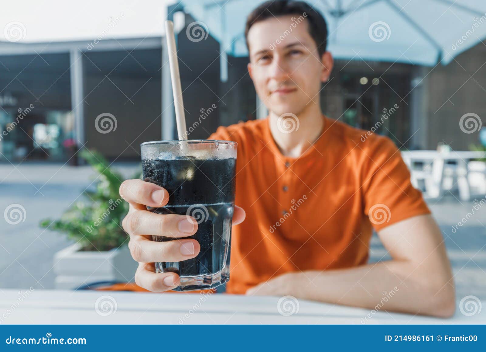 Man Drinks Sparkling Water in Black Color with Ice and Lemon with a ...