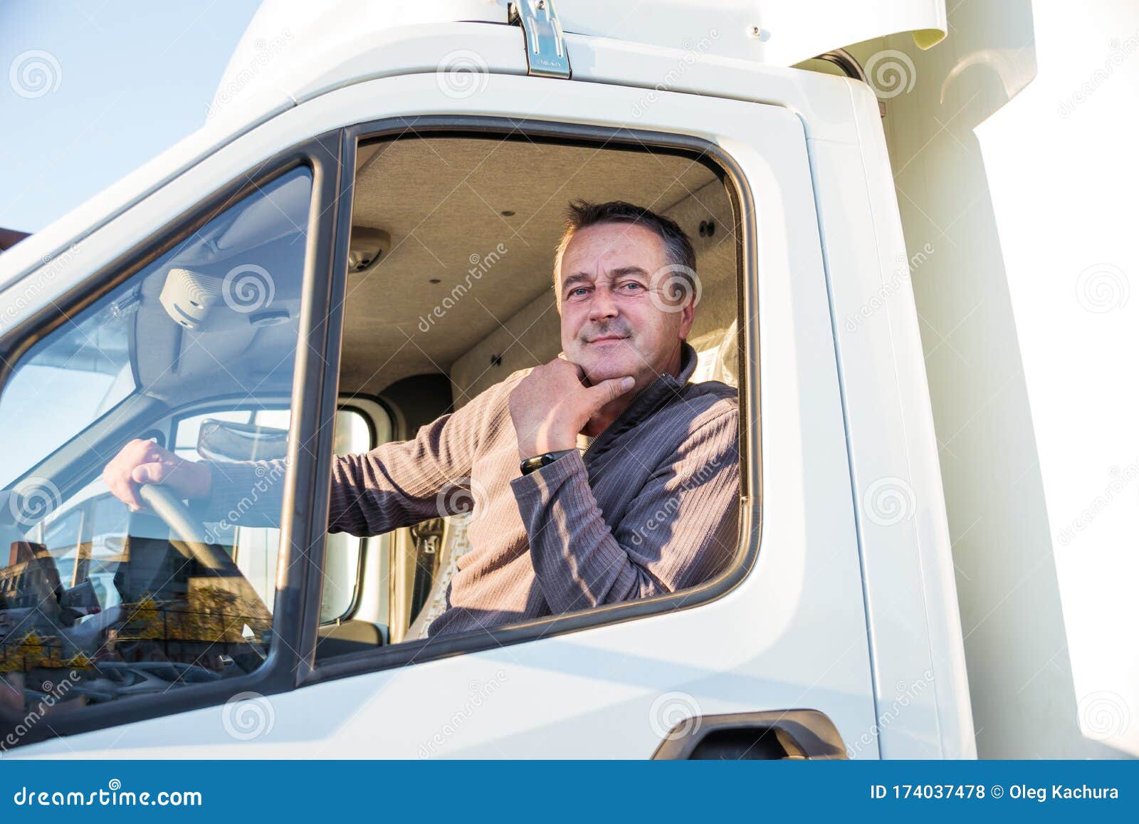 A Man Driver is Sitting in the Cab of a Modern Truck Stock Photo ...