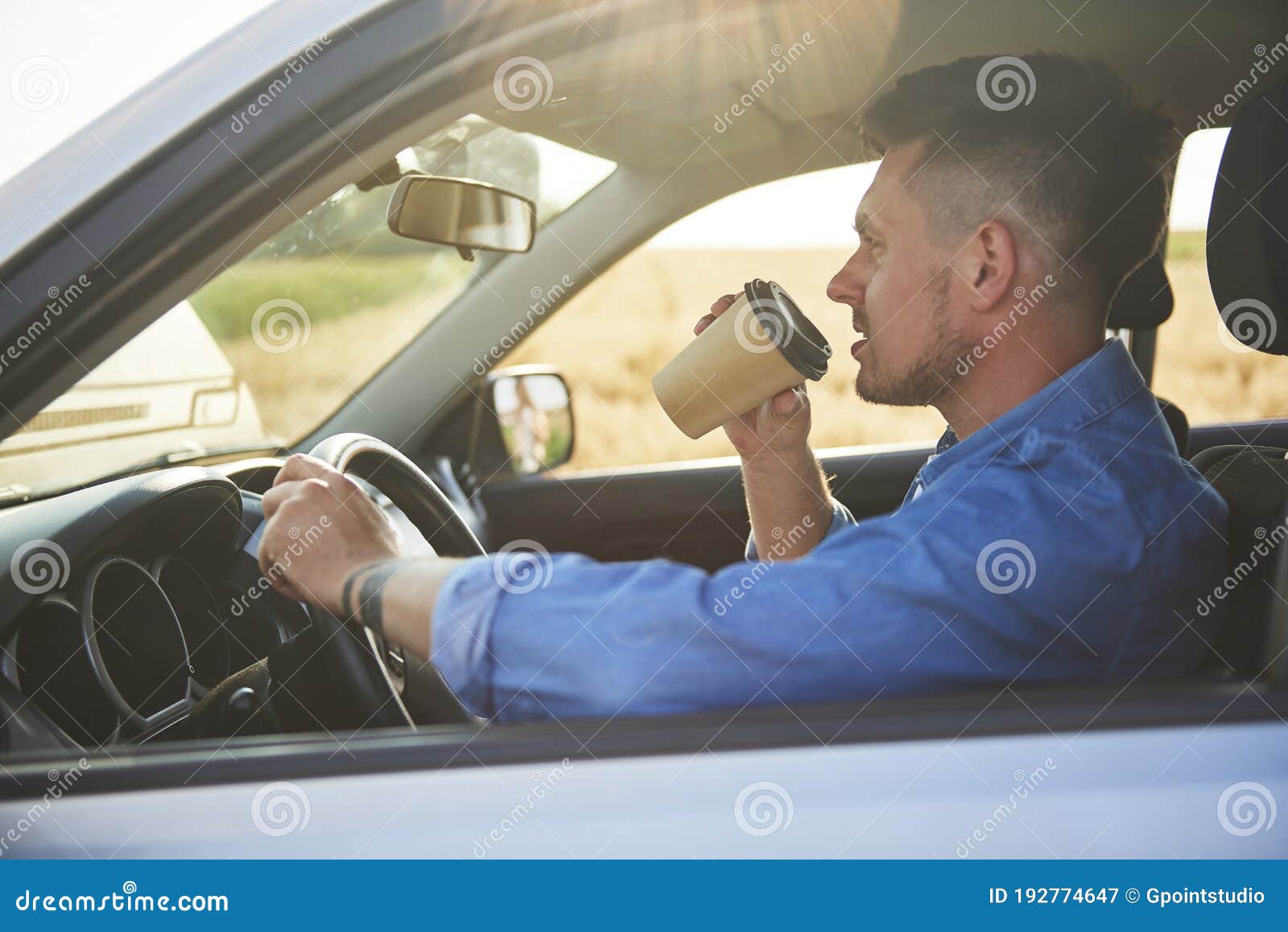 Young Man Driving a Car and Drinking Coffee in a Rush Stock Image ...
