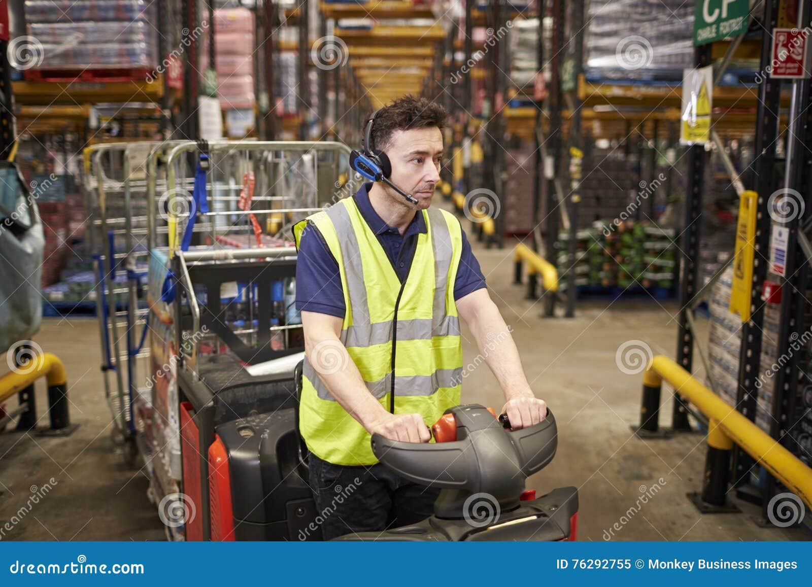 Man Driving a Tow Tractor through a Distribution Warehouse Stock Image ...
