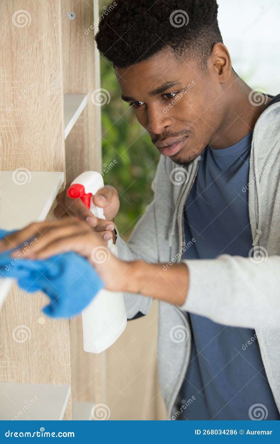 Man Dusting Bookshelf and Using Household Spray Stock Photo - Image of ...