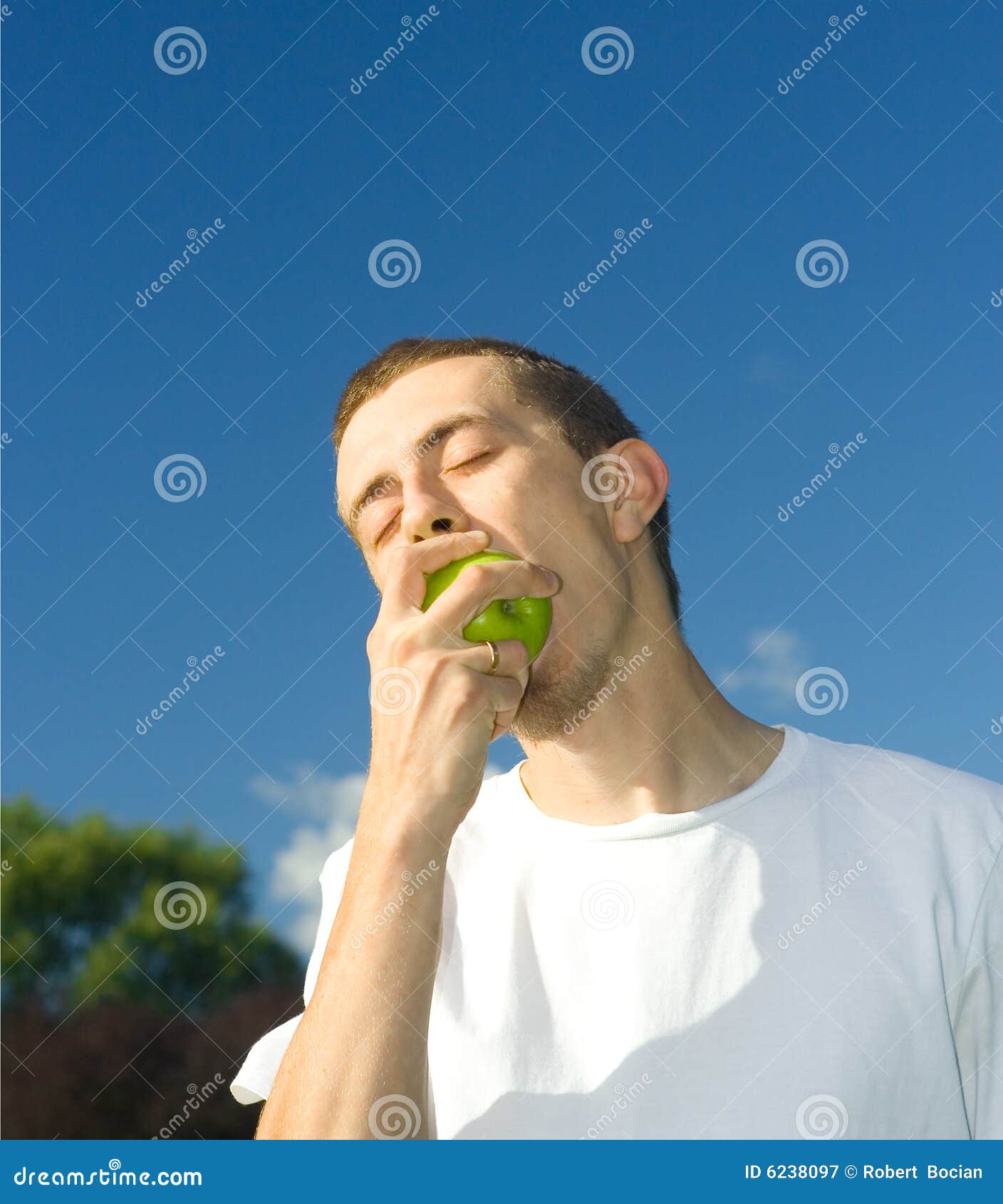 Man eating apple stock image. Image of clouds, attractive - 6238097