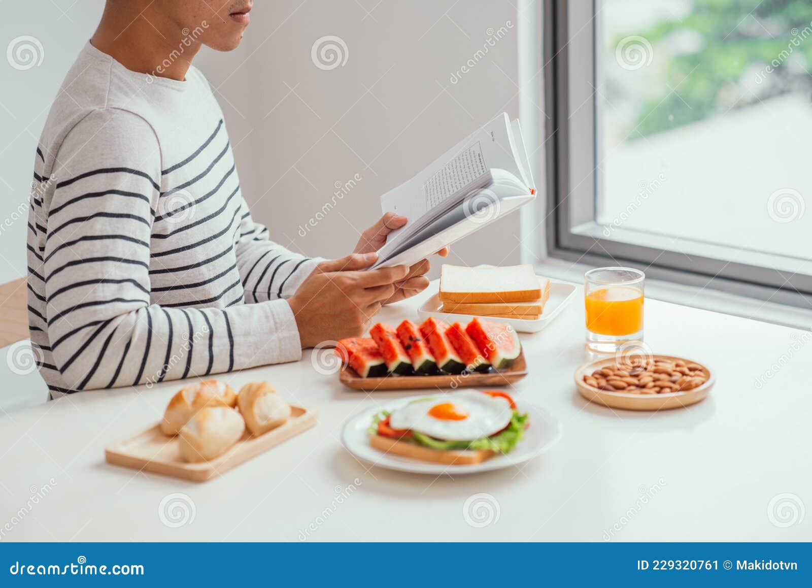 Man Eating Breakfast and Reading Book at Home Stock Image - Image of ...