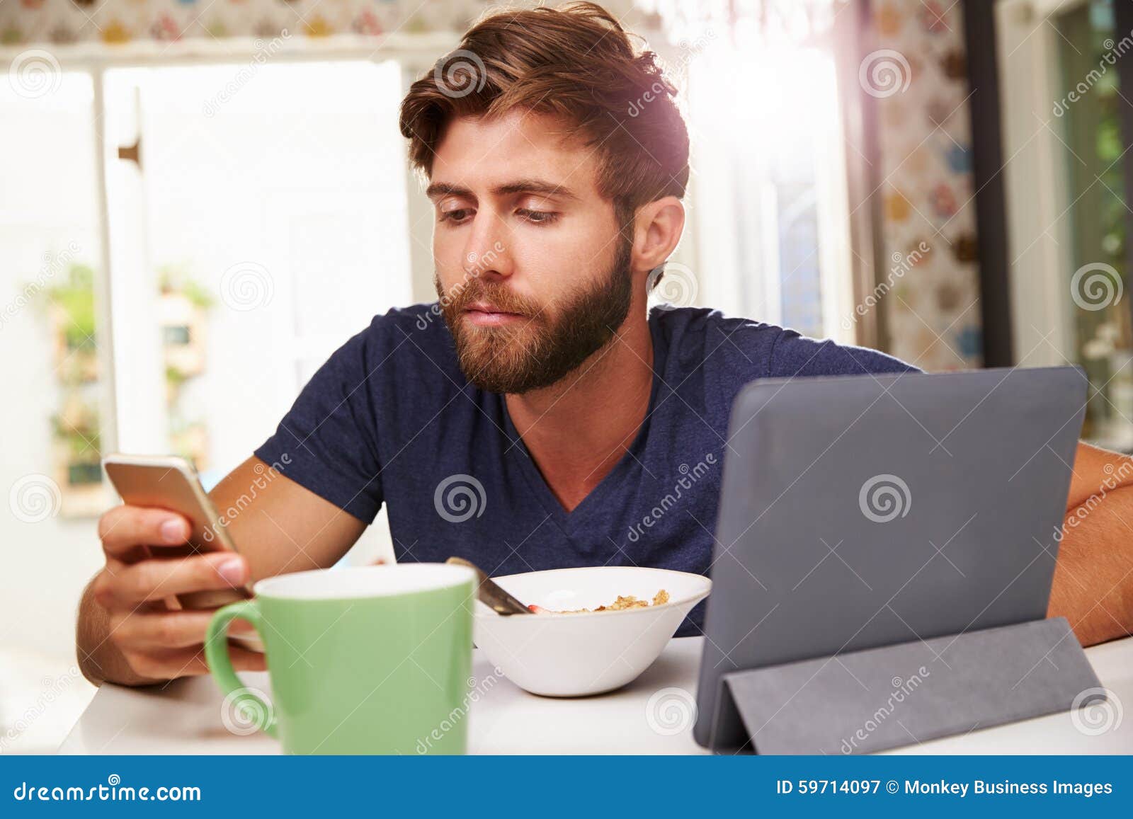 Man Eating Breakfast Whilst Using Digital Tablet and Phone Stock Image ...
