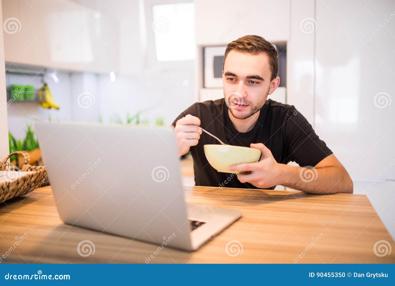 Man Eating Breakfast Whilst Using and Laptop at Kitchen Stock Photo ...