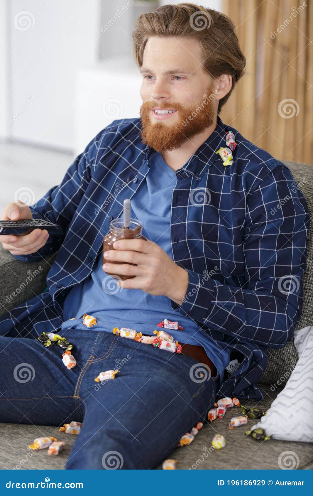 Man Eating Chocolate Holding Remote Control on Couch Stock Image ...