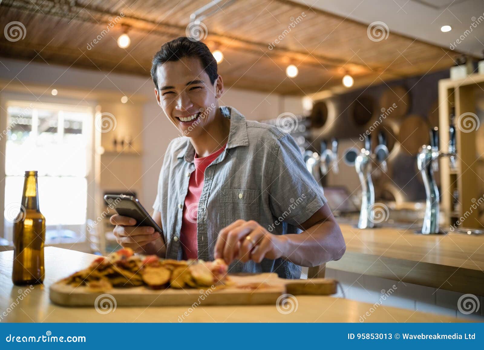 Man Eating Food in a Restaurant Stock Image - Image of beer, cellphone ...