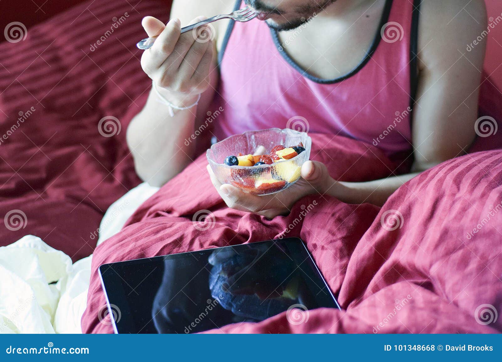 Man Eating Fruit and Using Tablet Computer Stock Photo - Image of bowl ...