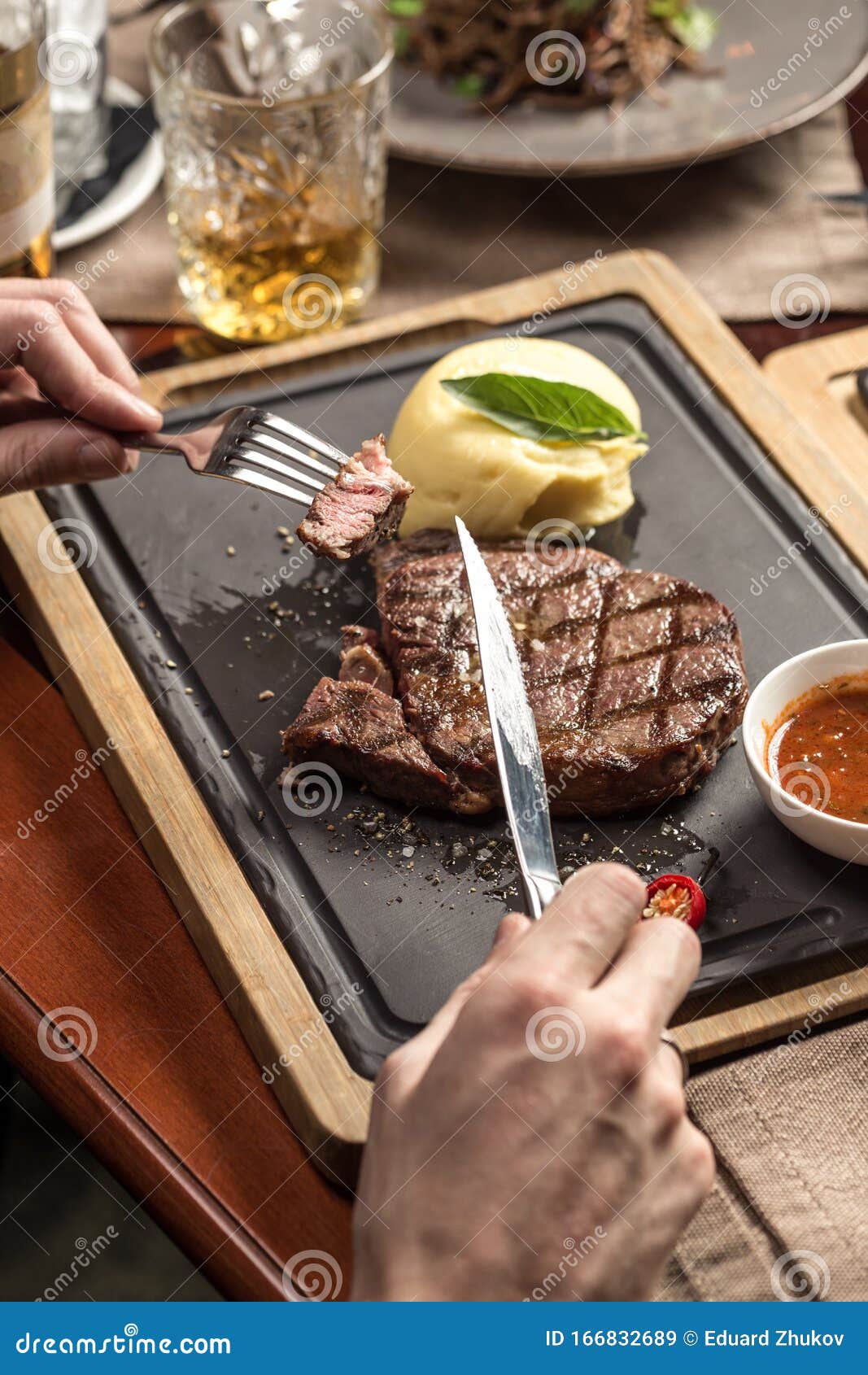 Man Eating Steak with Mashed Potato and Tomato Sauce at Restaurant ...