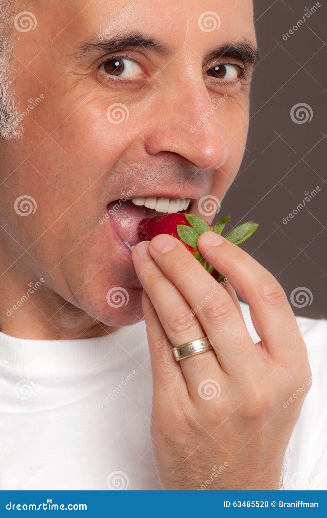 Man eating a strawberry stock photo. Image of happy, mature - 63485520