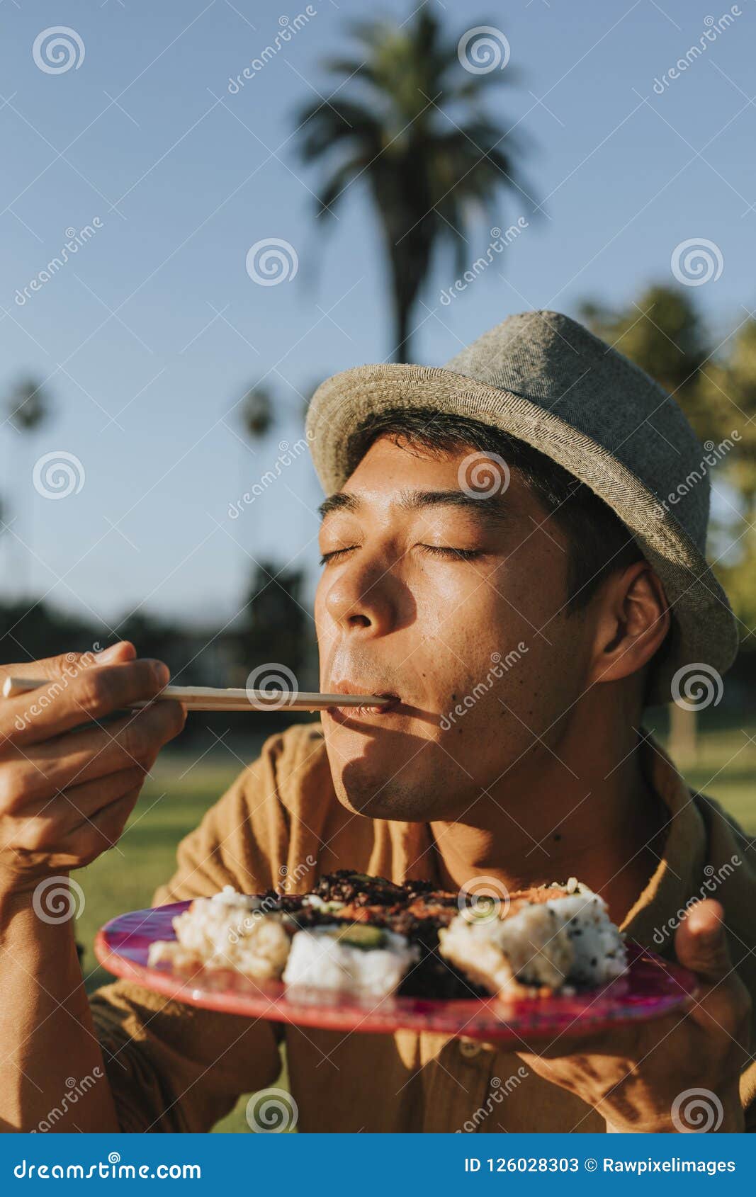 Man Eating Sushi in the Park Stock Image - Image of person, gesture ...