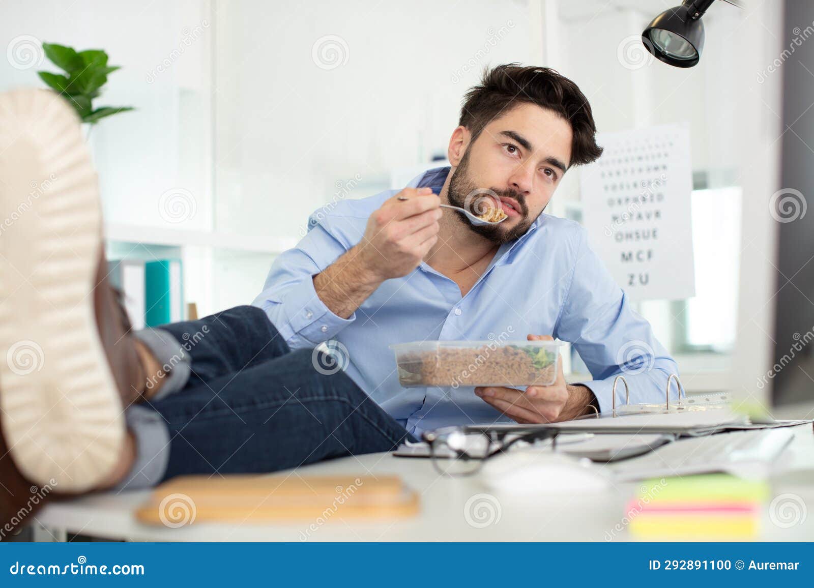 Man Eating in Workplace with Feet on Desk Stock Photo - Image of ...