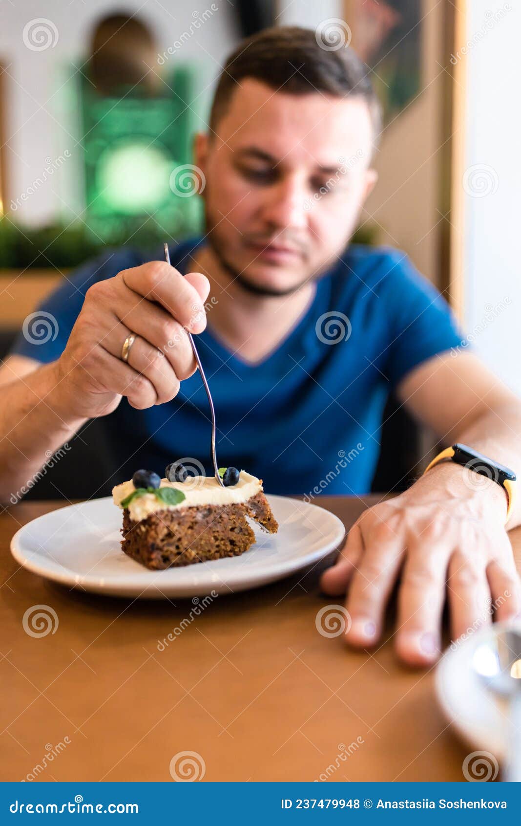 A Man Eats a Cake with Blueberries in a Cafe. Stock Photo - Image of ...