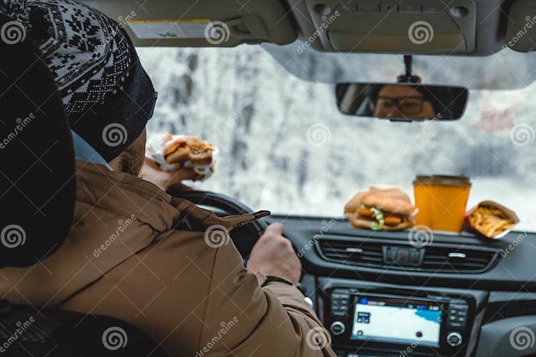 A Man Eats while Driving a Car. Stop for Lunch Stock Photo - Image of ...
