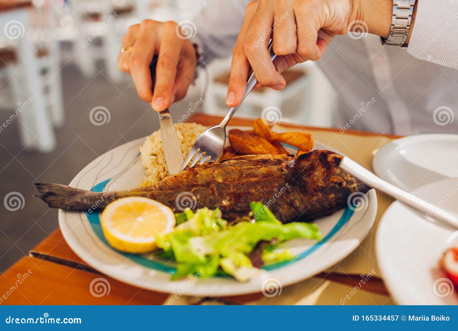 Man Eats Fish with Vegetables in Outdoors Restaurant. Fresh Seafood ...