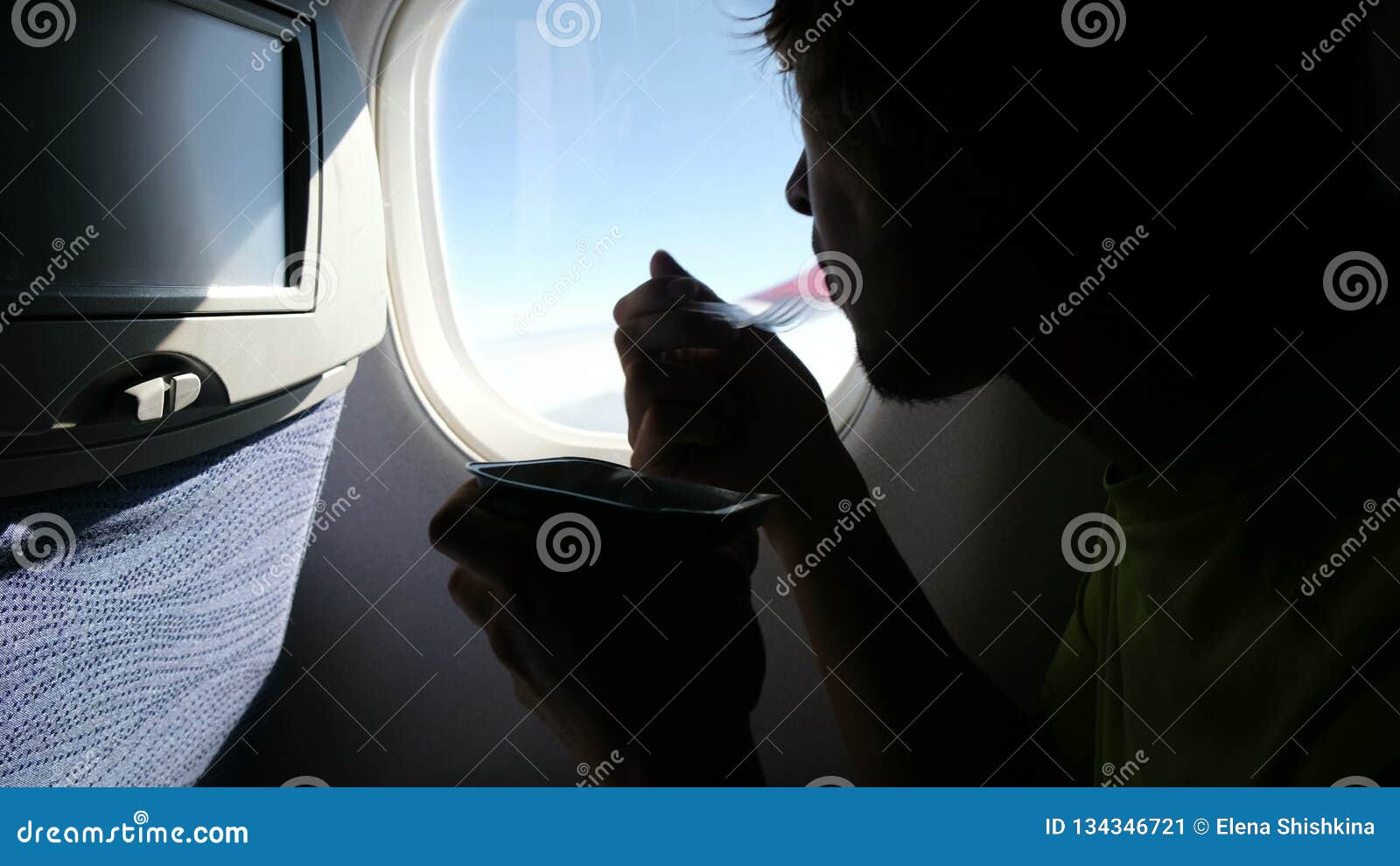 Man Eats Food with a Fork while Sitting by a Window in an Airplane in ...
