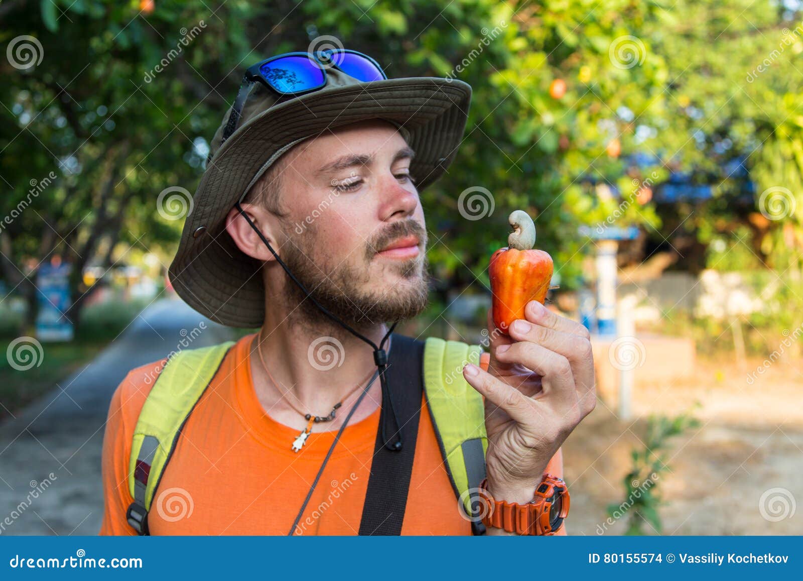 Man Eats Nuts Isolated on a Light Background.nMan Shows a Set of Nuts ...