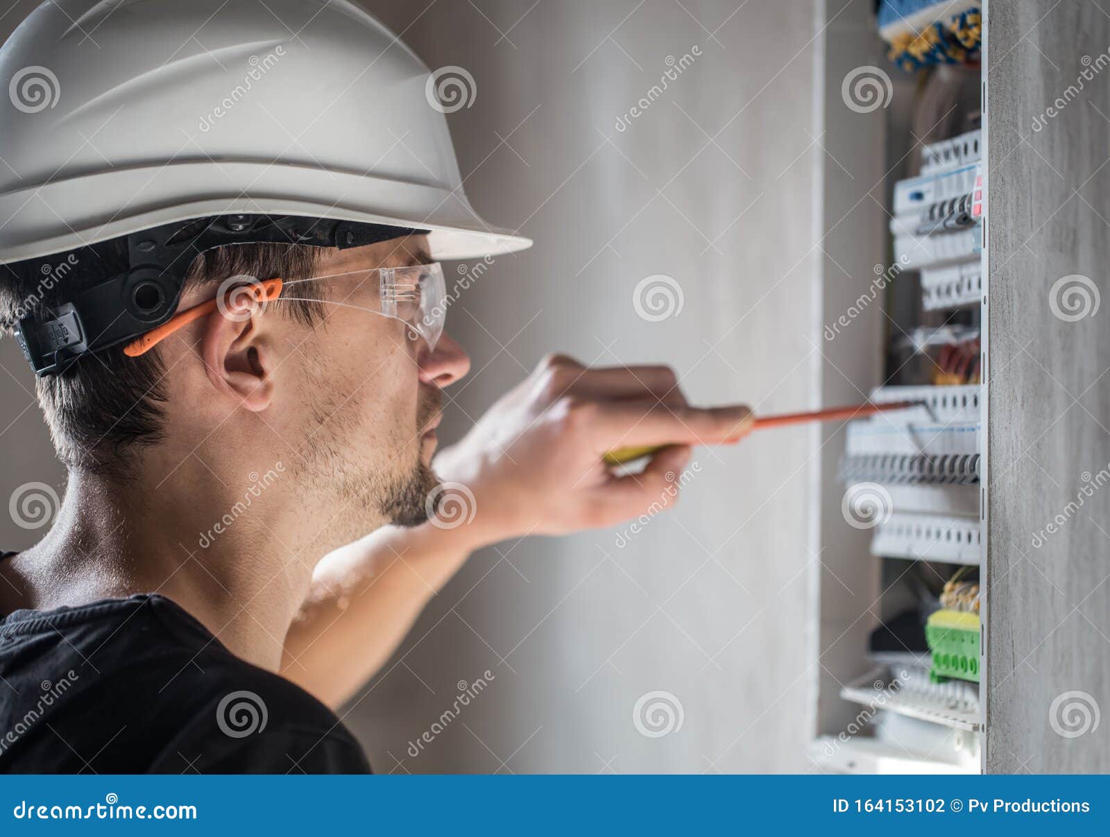 Man, an Electrical Technician Working in a Switchboard with Fuses ...