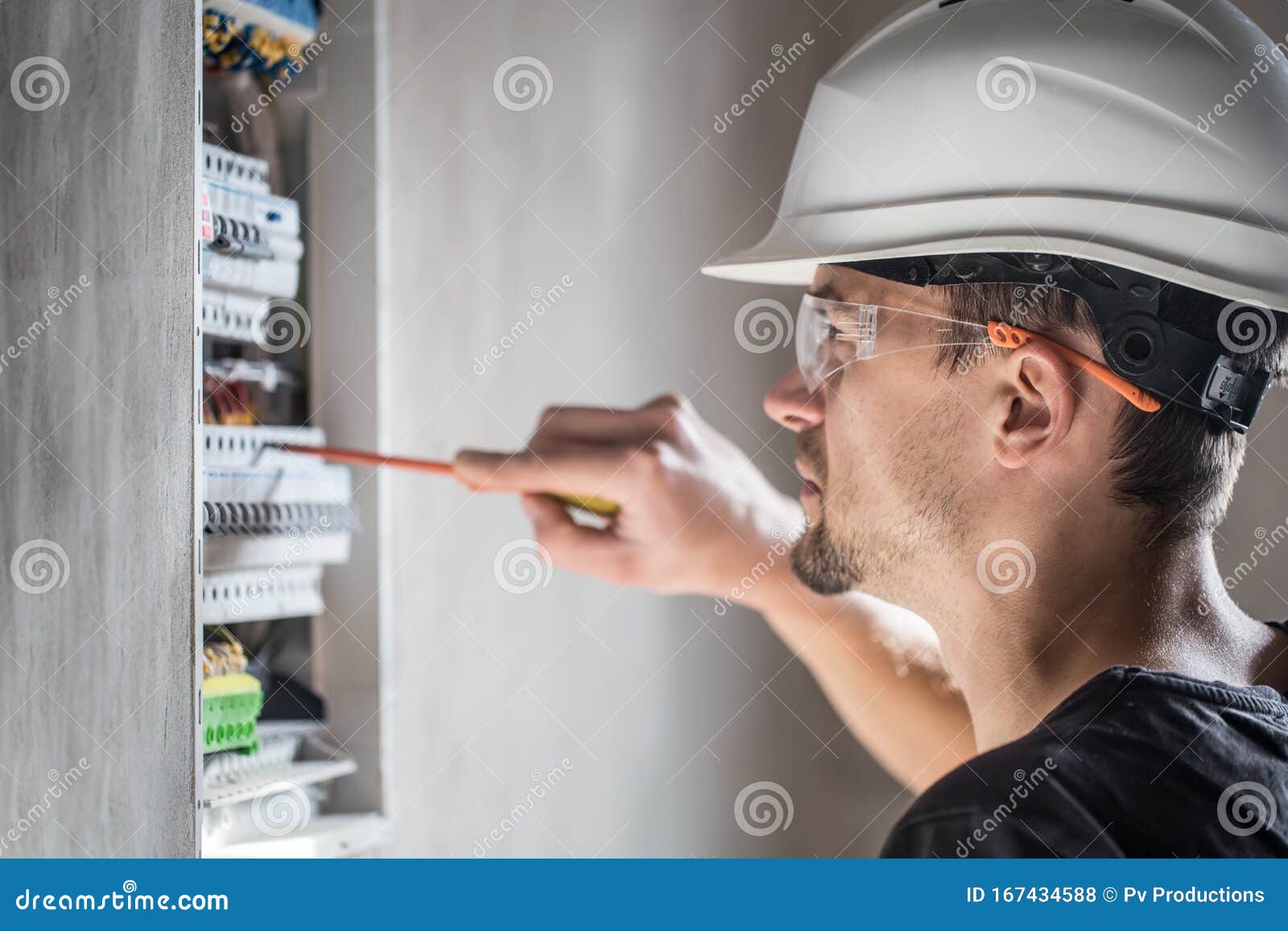 Man, an Electrical Technician Working in a Switchboard with Fuses ...
