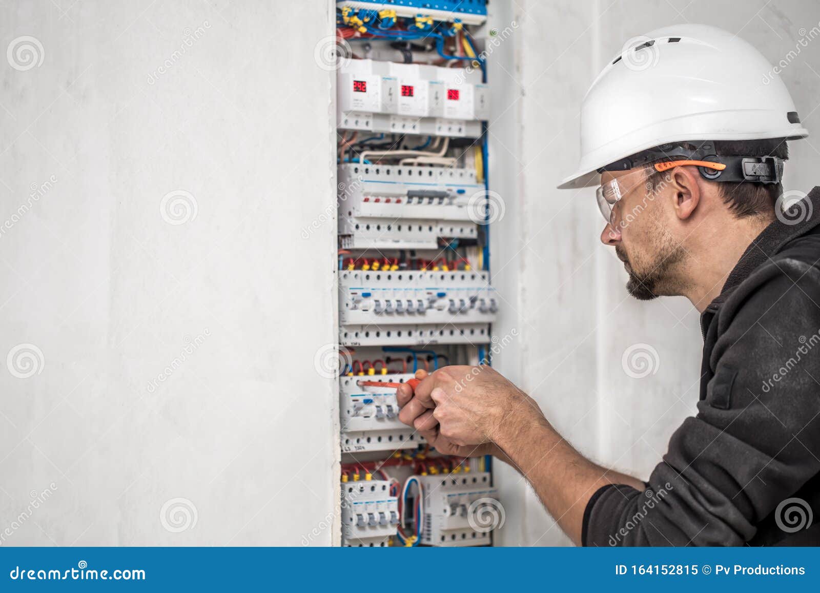 Man, an Electrical Technician Working in a Switchboard with Fuses ...
