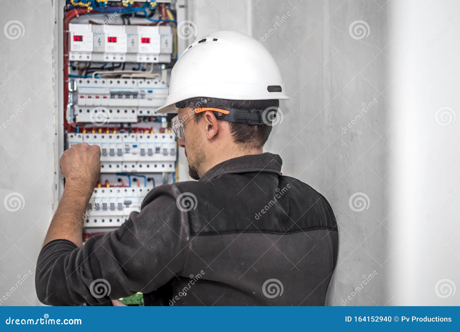 Man, an Electrical Technician Working in a Switchboard with Fuses ...